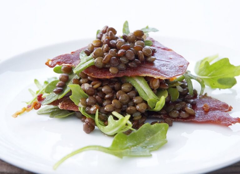 Salade van notensla, linzen, gedroogde ham en krullen van Parmezaanse ...